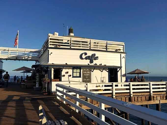 The iconic white building at pier's end beckons like a lighthouse for hungry souls seeking coastal bliss.