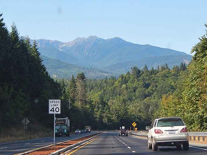 Mountains ahead, forests flanking, and a speed limit that suggests someone actually wants you to enjoy the view.