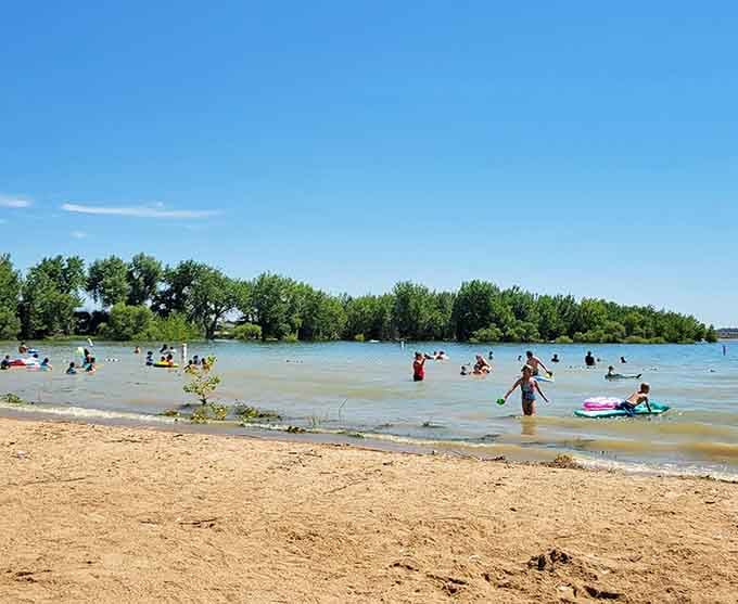 Families splash in shallow waters while that brilliant blue sky reminds you why postcards exist in the first place.