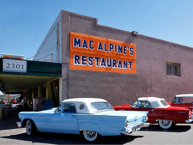 That bold orange sign and those classic cars aren't props; this is authentic Americana still serving happiness daily.
