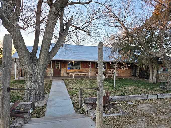That concrete walkway through the trees leads to stone-and-wood authenticity you can't fake with a decorator's catalog.