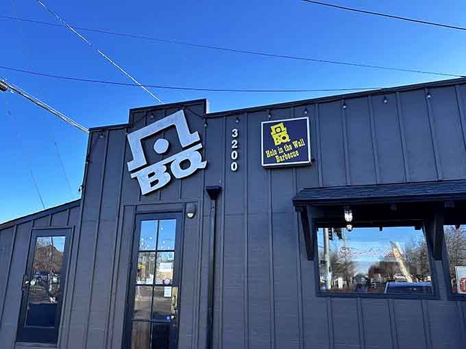 That industrial gray exterior under blue skies means serious barbecue business is happening inside those walls.