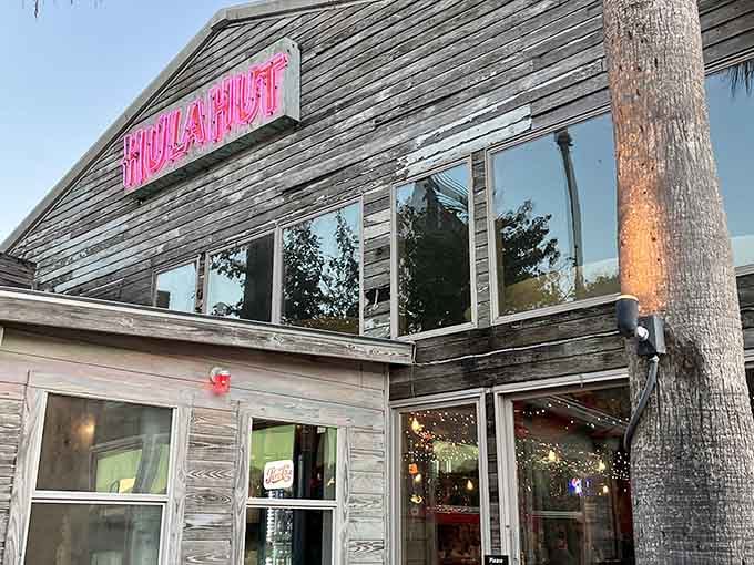 That pink neon sign and weathered wood exterior promise something wonderfully unexpected is waiting inside for you.