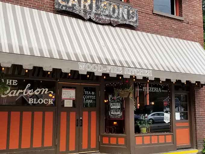 The wood-fire kitchen promises authentic flavors while that vintage awning whispers tales of a bygone era.