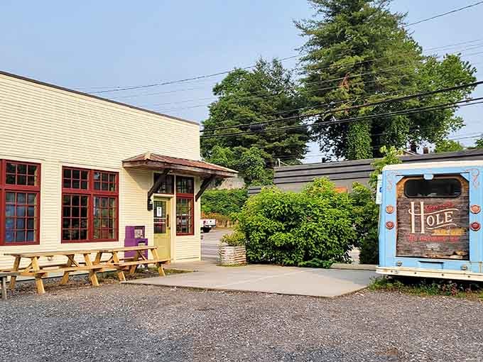The yellow building with the cheerful blue food truck out front is your gateway to donut enlightenment.