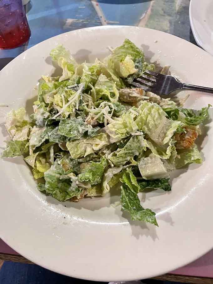 Fresh romaine, shaved parmesan, and croutons prove that even salads get star treatment here.