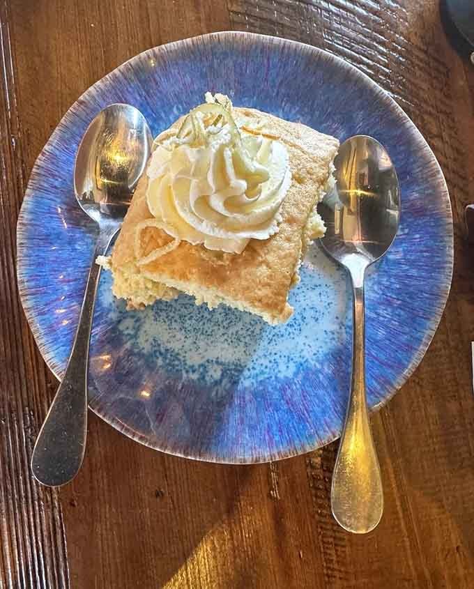 Tres leches cake crowned with whipped cream on that stunning blue plate is dessert done absolutely right.