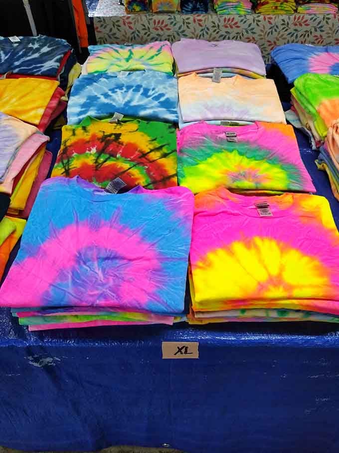 Tie-dye shirts stacked in psychedelic glory, because apparently the 1960s called and said they're making a permanent comeback here.