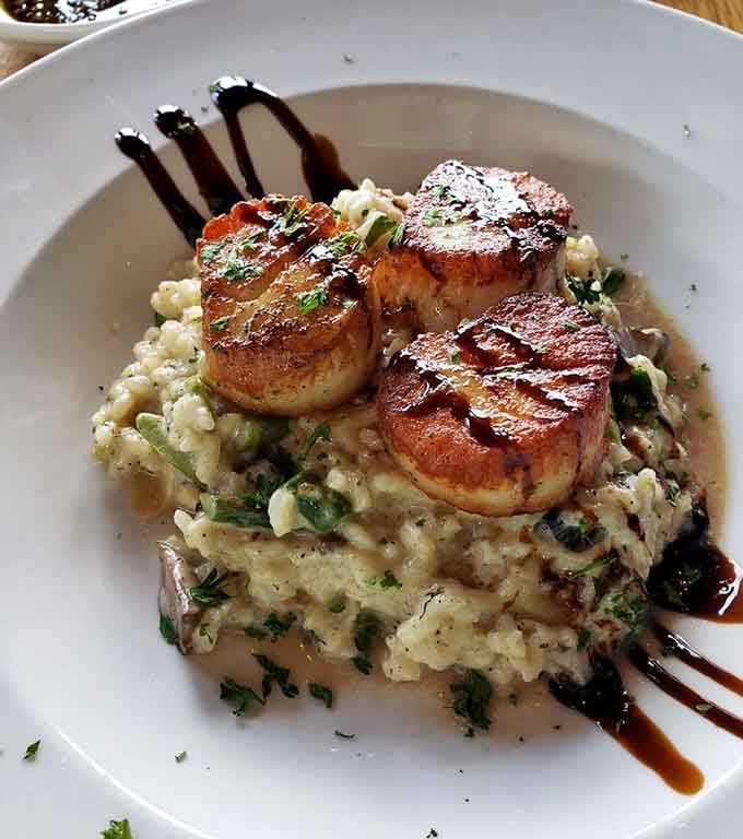 Perfectly seared scallops over risotto with balsamic drizzle look almost too pretty to eat, but you'll manage somehow.