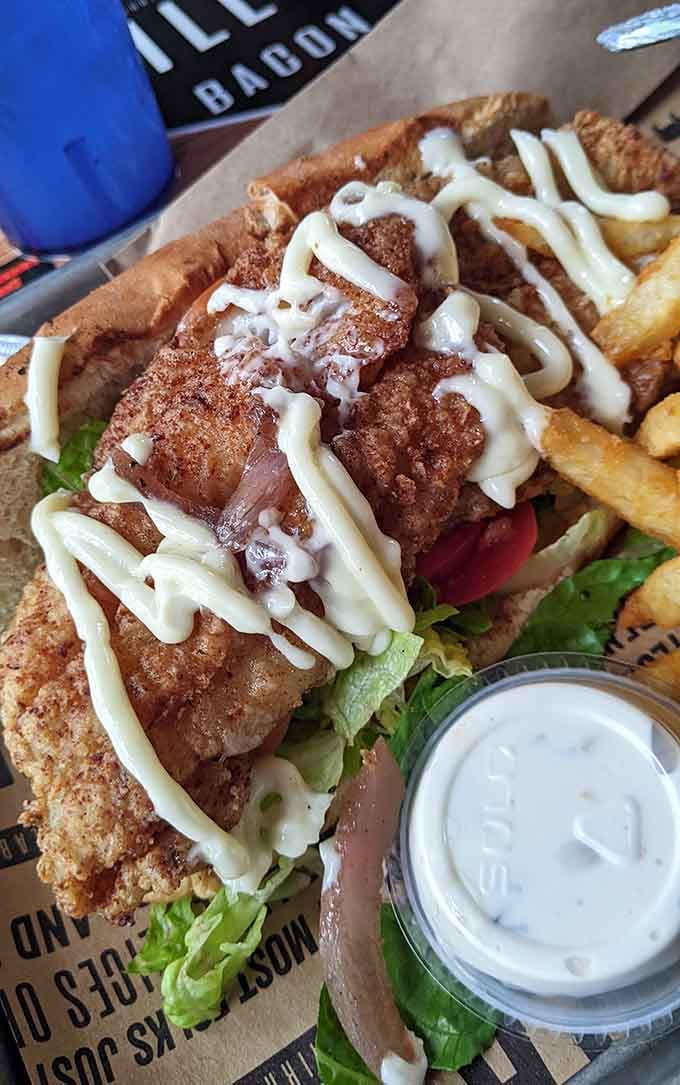 That po'boy is loaded with fried goodness and drizzled with sauce, making Louisiana proud right here in Alabama.