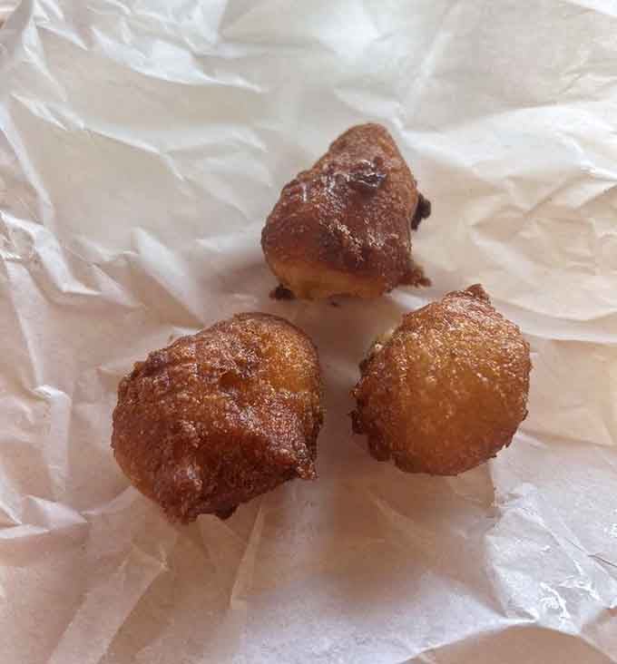 Three golden hush puppies that prove the best things come in small, perfectly fried packages of cornmeal joy.
