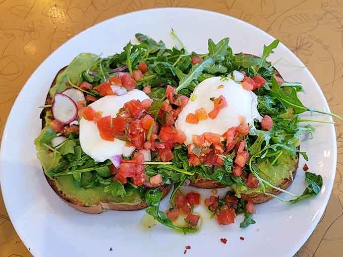 Avocado toast elevated with poached eggs and fresh arugula, proving healthy can be downright crave-worthy.