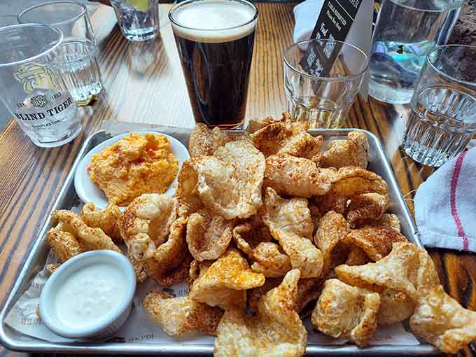 A mountain of crispy pork rinds next to a dark beer, because sometimes simple pleasures are the most satisfying ones.