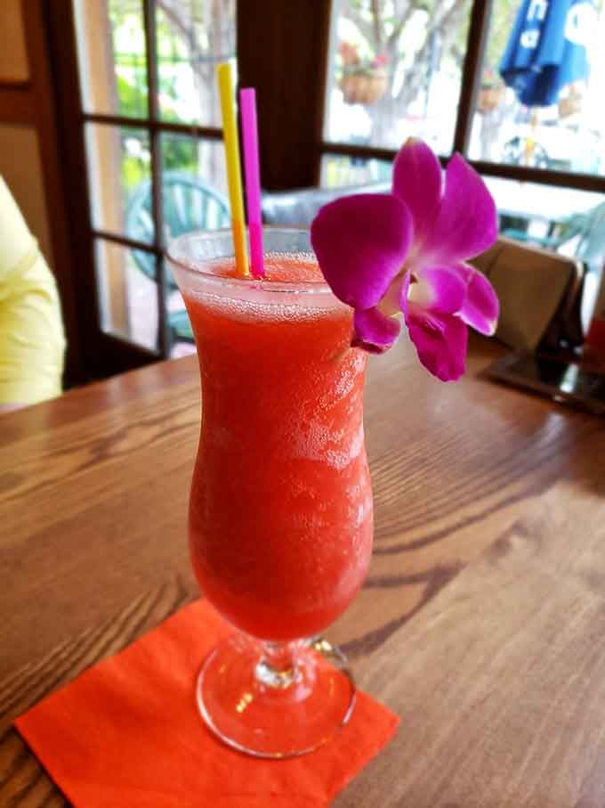 A frozen daiquiri garnished with an orchid, because sometimes your drink deserves to feel fancy too.