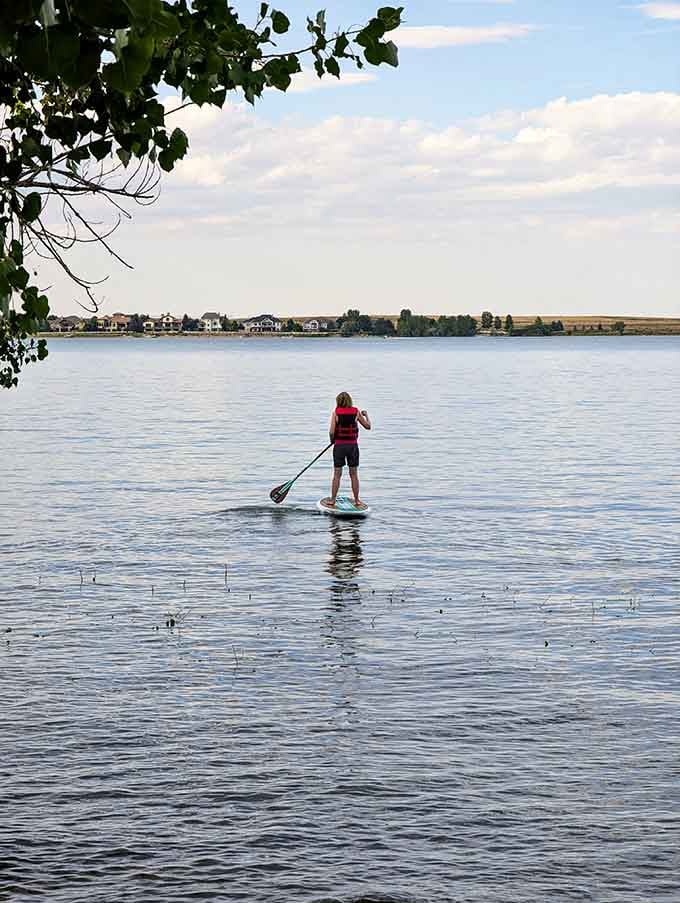 Paddleboarding across glassy water at sunset, channeling your inner zen master without the yoga pants.