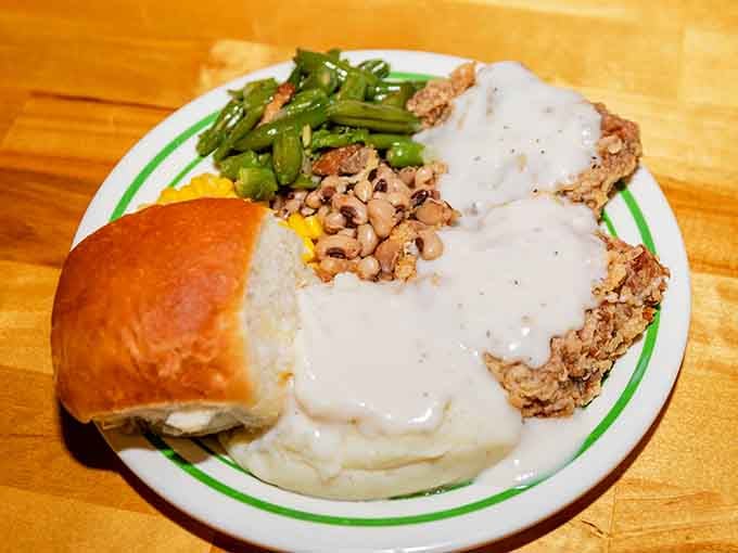 Chicken fried steak drowning in gravy, surrounded by vegetables that actually taste like someone seasoned them with care.