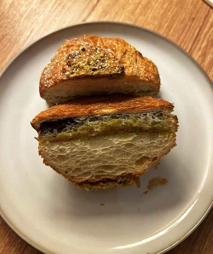 Pistachio chocolate croissants sliced open to reveal those gorgeous, airy layers of buttery pastry heaven within.