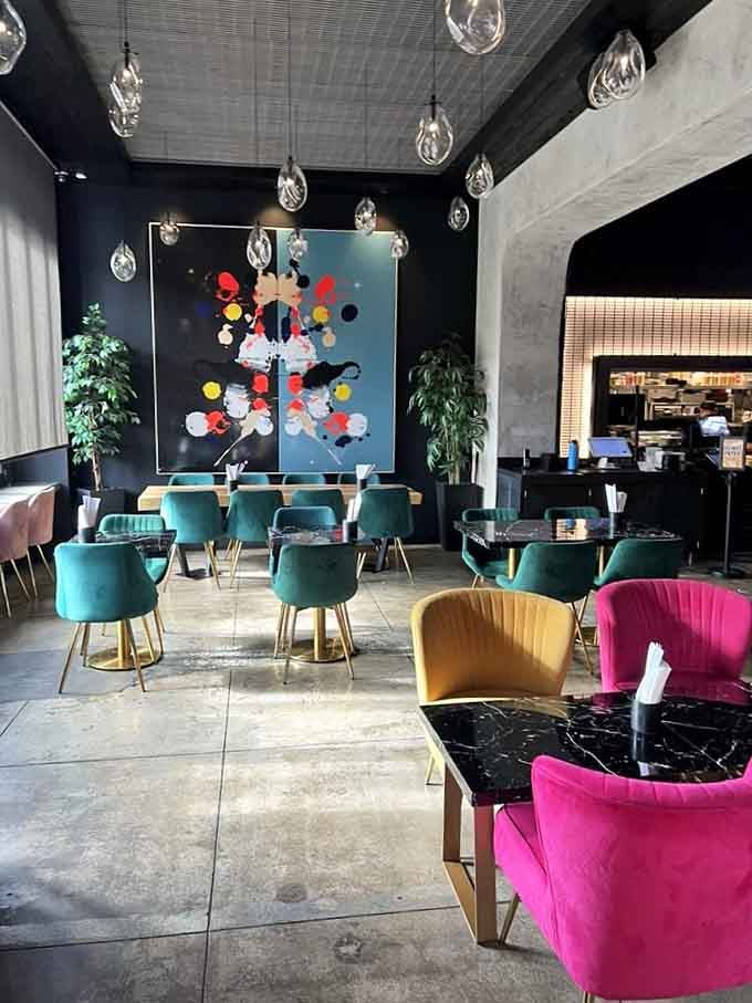 Colorful velvet seating and modern art create a space where Instagram photos happen naturally, no filter required for this beauty.