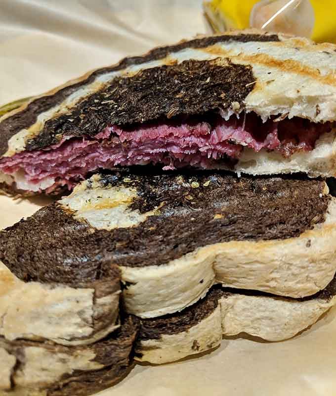 That pastrami sandwich cross-section reveals layers of flavor that could make a grown person weep with joy.