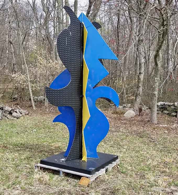 Bright blues and yellows pop against textured black, bringing unexpected color to the typically monochrome sculpture world.