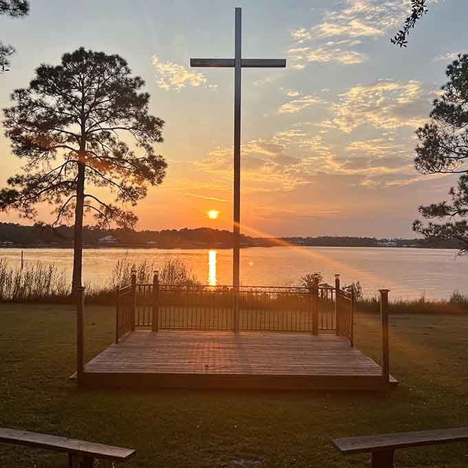 Golden hour paints the cross and water in heavenly light, creating a moment of pure tranquility worth savoring.