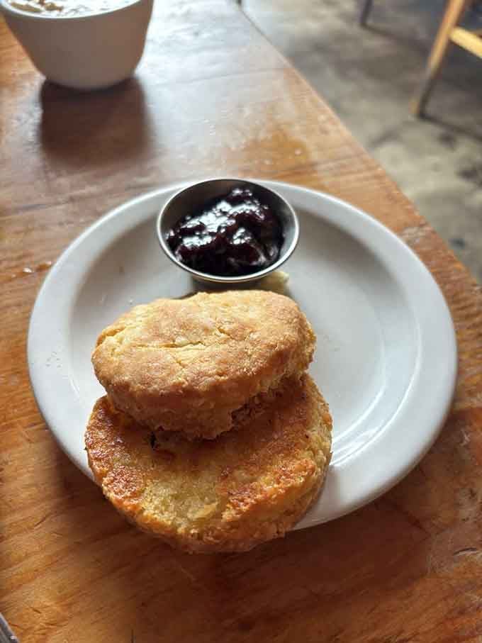 Homemade biscuits stacked like fluffy towers of butter-laden joy, jam on the side for good measure.