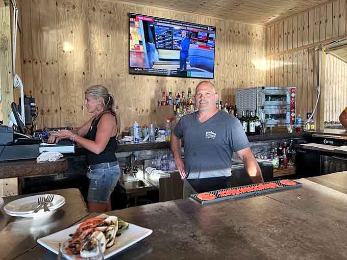 The bar area features rustic wood paneling and friendly faces ready to mix your cocktail of choice.