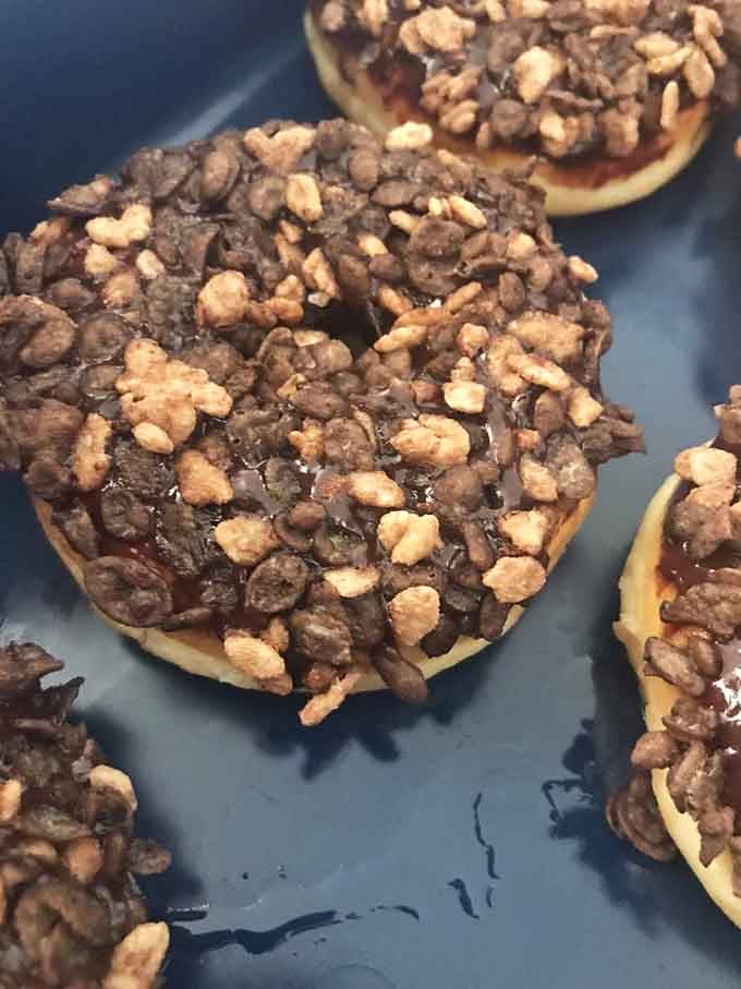 Filled donuts topped with chocolate and peanuts, turning breakfast pastries into legitimate reasons to celebrate ordinary Tuesdays.
