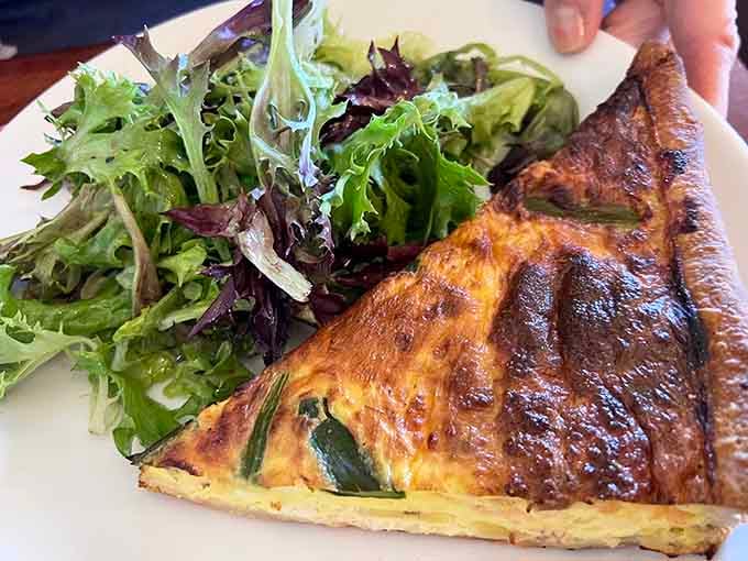 Fresh quiche with a golden crust that's flaky perfection, served with crisp greens for a lighter but equally satisfying option.