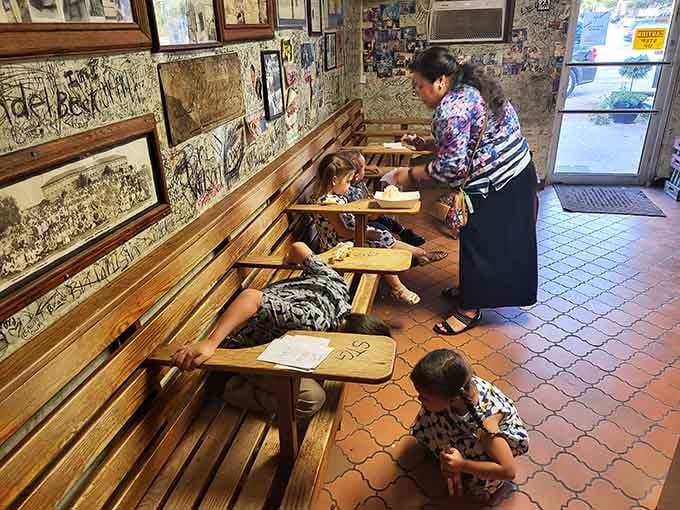 Three generations sharing burgers on wooden benches is exactly how family meals should look and feel.
