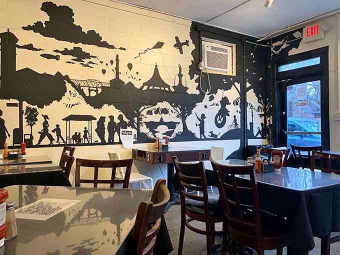 That striking black and white mural transforms a simple breakfast spot into an Instagram-worthy destination with serious artistic chops.