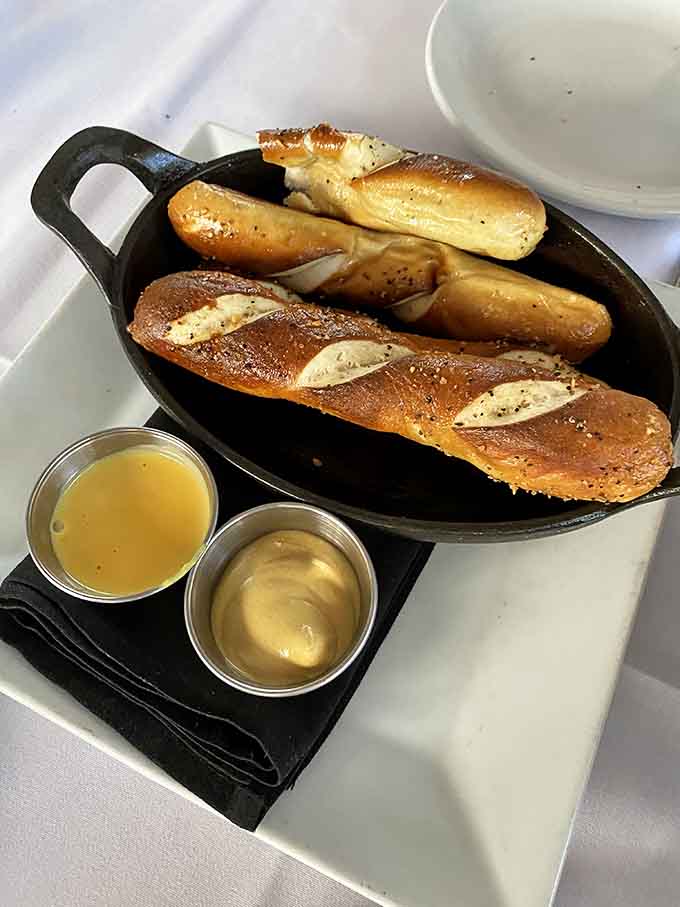 Warm pretzels served in a skillet with dipping sauces, the perfect start to any meal here.