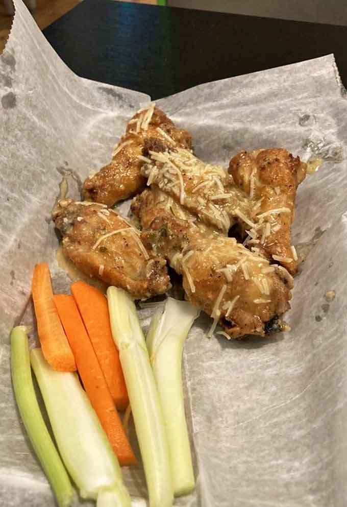 Golden, crispy wings with fresh veggies proving that sometimes the simplest pleasures are the best ones.