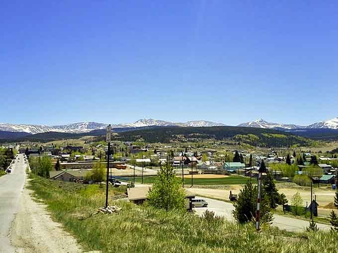 The town spreads across the valley with mountains standing guard, looking exactly like a postcard come to life.