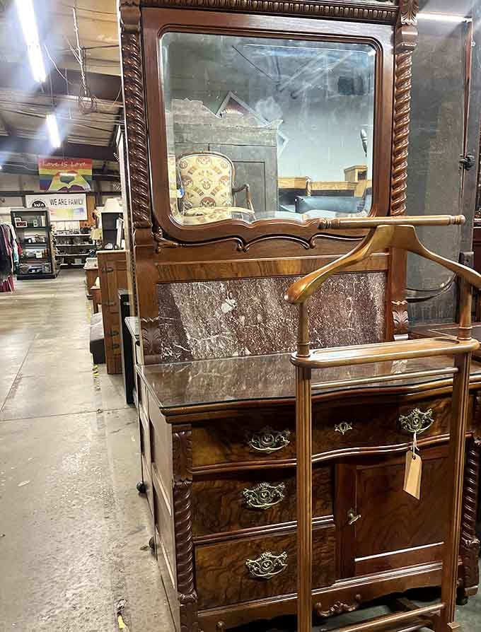 This ornate dresser with beveled mirror belongs in a Victorian novel, complete with carved details and brass hardware.