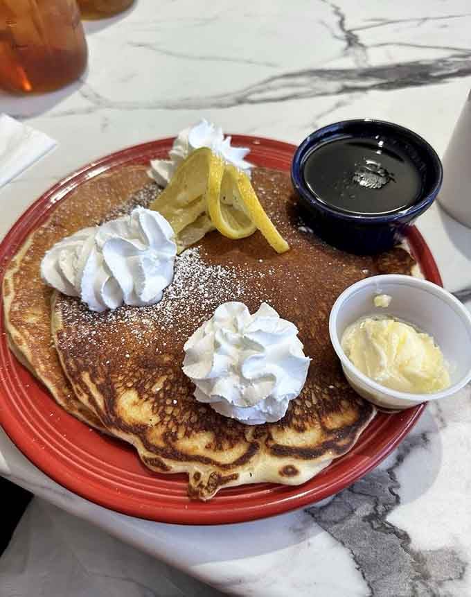 Fluffy pancakes topped with whipped cream and lemon that look like they're ready for their close-up and your fork.