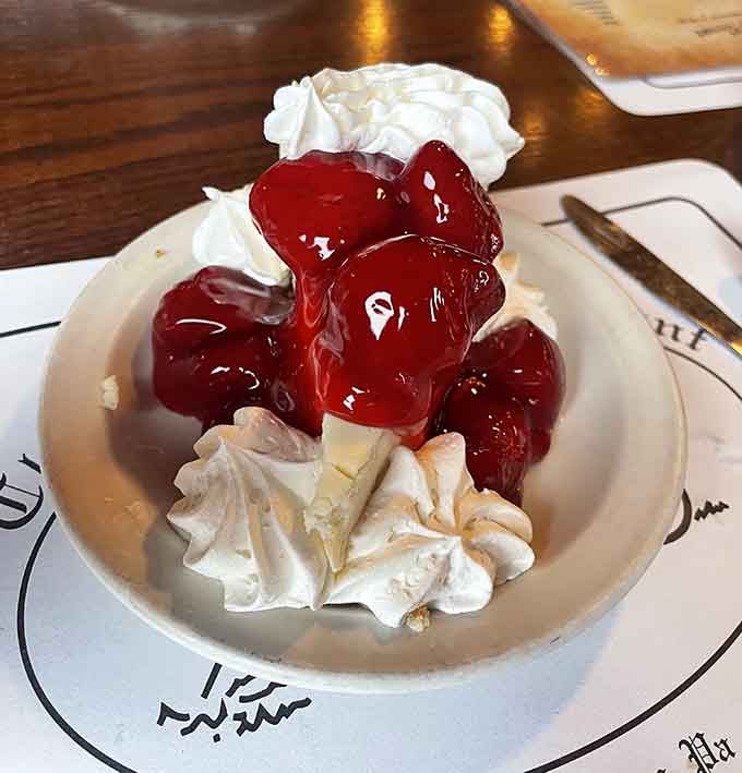 Cheesecake crowned with glossy cherries and whipped cream, proving that dessert is always a good life choice.