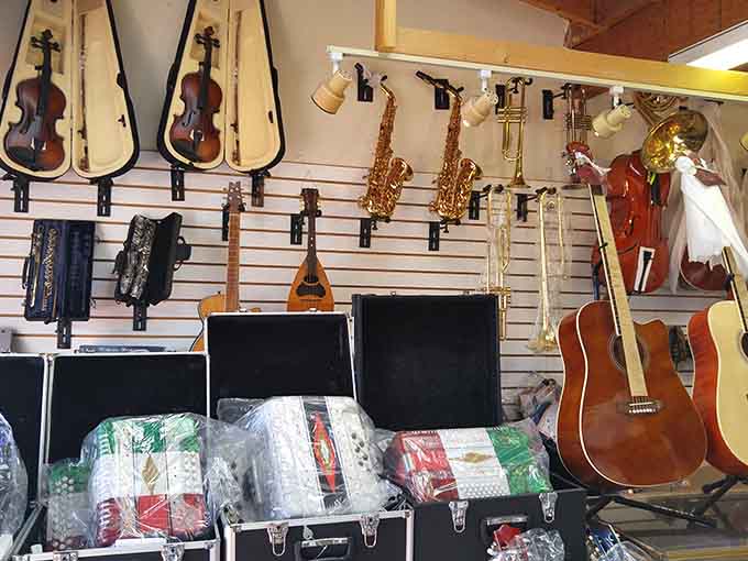 Musical instruments hanging like a symphony waiting to happen, from guitars to saxophones and beyond.