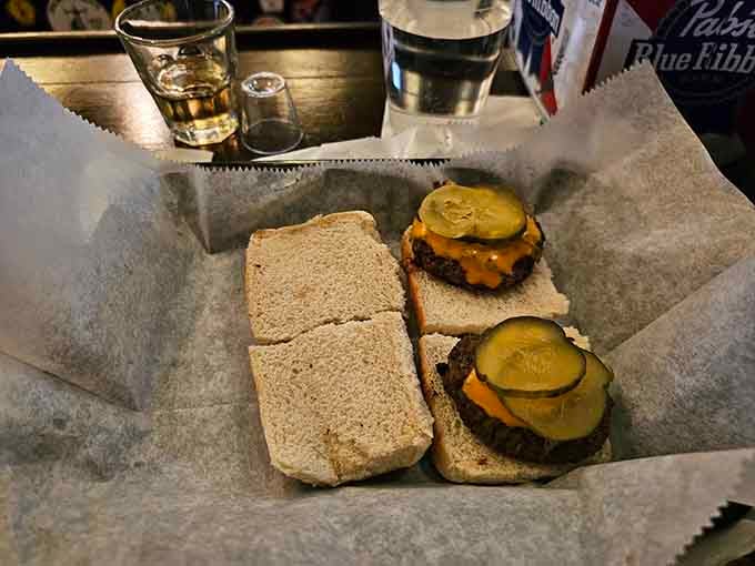 Two perfect sliders with pickles and cheese, simple pleasures that have satisfied customers since your grandparents were young.