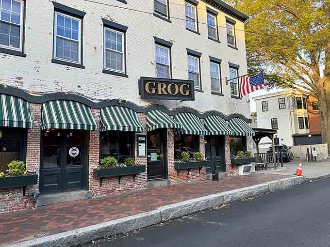 The Grog's green-and-white awnings beckon like a friendly wave, inviting you into a Newburyport institution that's fed generations.