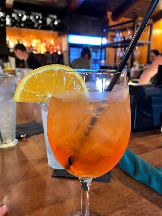 An Aperol spritz with a fresh orange slice brings a touch of Italian sunshine to your lakeside dining experience.