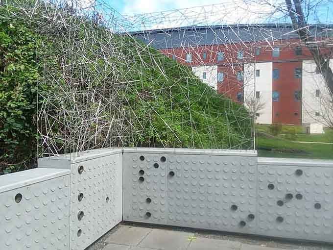 This wire mesh sculpture stands as a powerful artistic statement about confinement and mental health treatment.