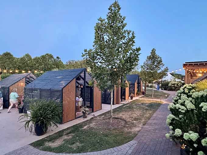 Those charming outdoor cabanas are basically tiny houses for wine lovers who appreciate architectural whimsy and privacy.