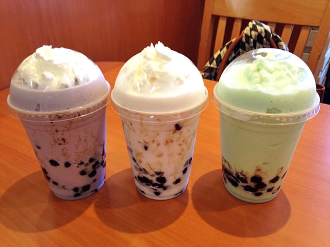 Three boba drinks topped with whipped cream, making hydration feel like the best decision you've made all day.