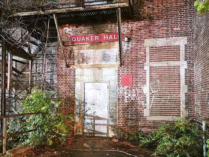 Quaker Hall stands weathered and worn, nature slowly reclaiming what humans have abandoned to time.