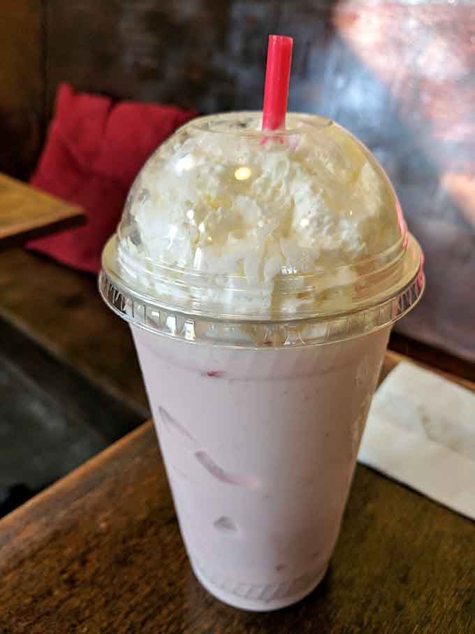 Strawberry shake topped with whipped cream that looks like a cloud you'd happily float away on.