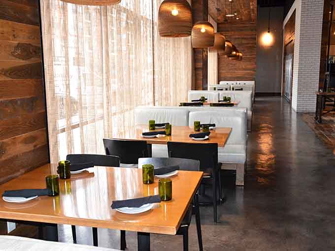 Reclaimed wood and thoughtful design create spaces where conversations flow as smoothly as the organic wine selection.