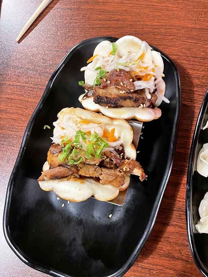 Fluffy steamed buns cradle spicy pork belly in what might be the perfect handheld happiness delivery system.