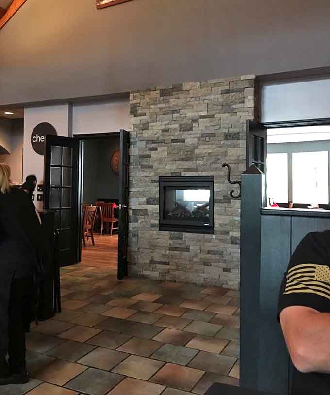 Stone fireplace, open layout, and that inviting glow? This is dining done right, folks.