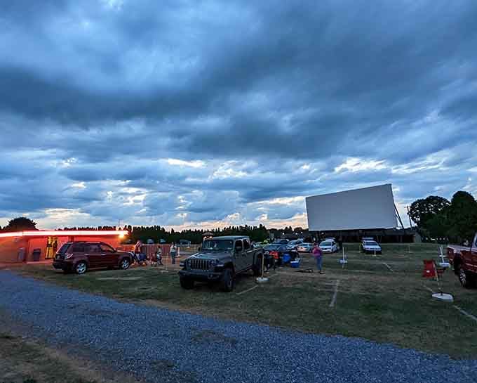 Dramatic skies provide the perfect backdrop as moviegoers arrive early to claim their favorite viewing spots before showtime.